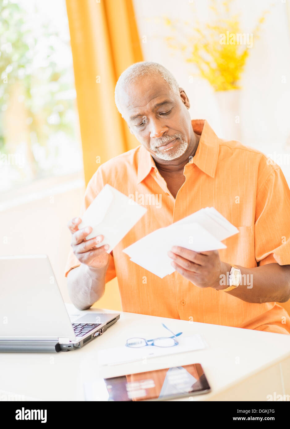 Portrait of man sorting mail at home Stock Photo - Alamy