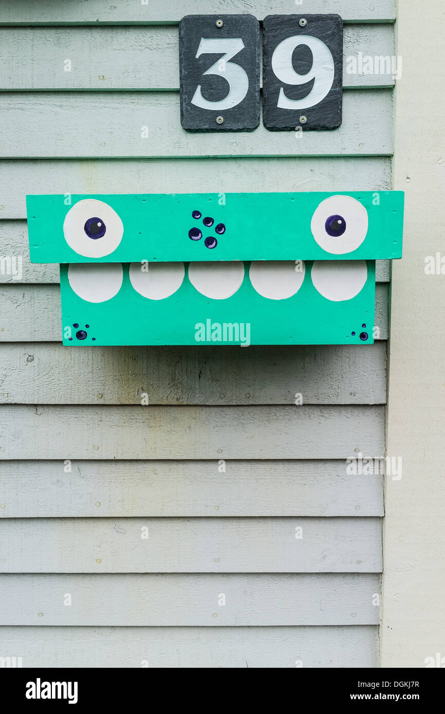 A custom made mailbox painted turquoise with eyes and teeth on the ...