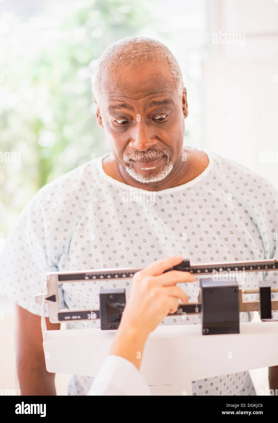 Shocked man on weight scale Stock Photo - Alamy