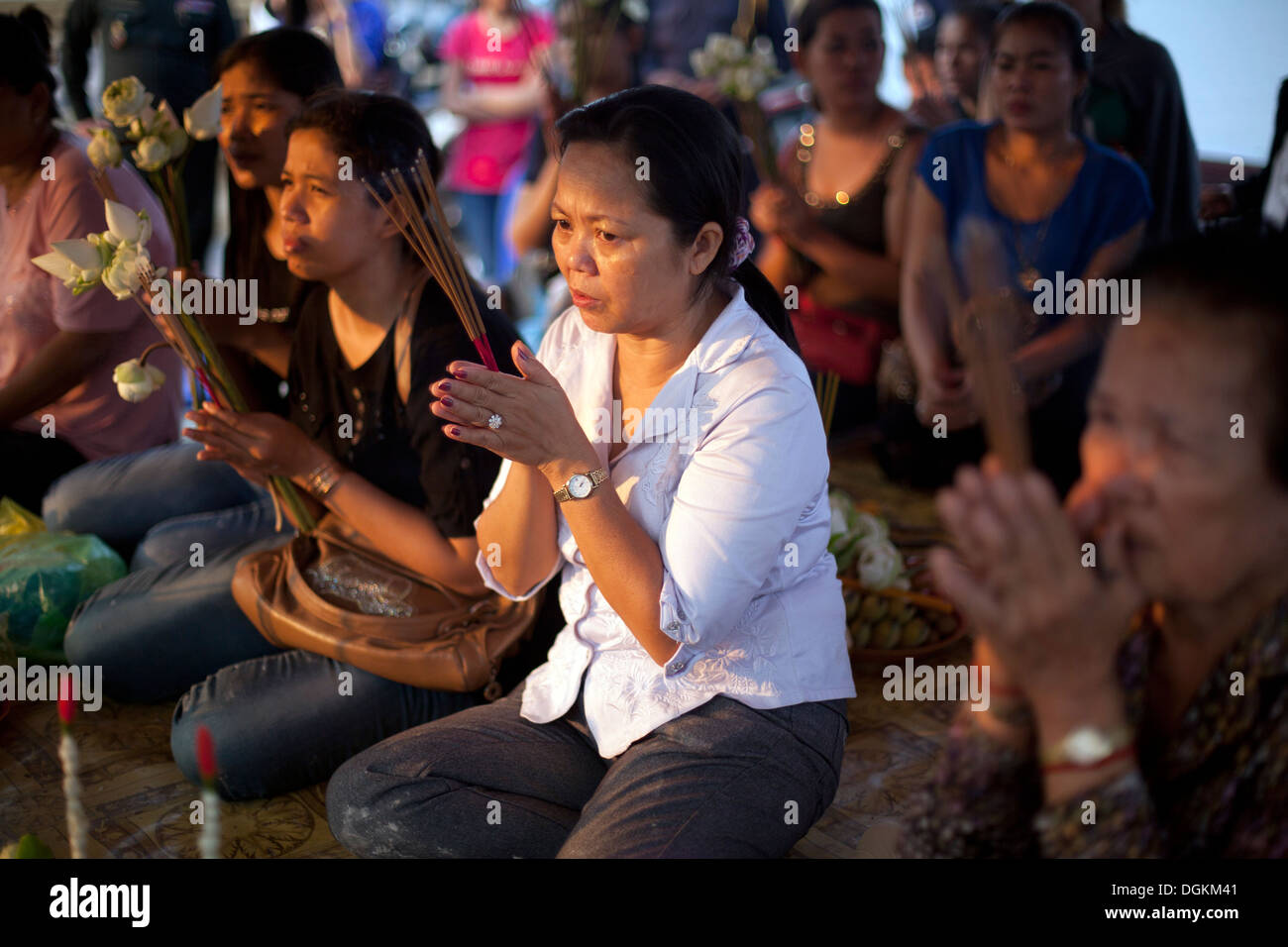 Cambodians pray at a small shrine next to the Mekong River in Phnom ...