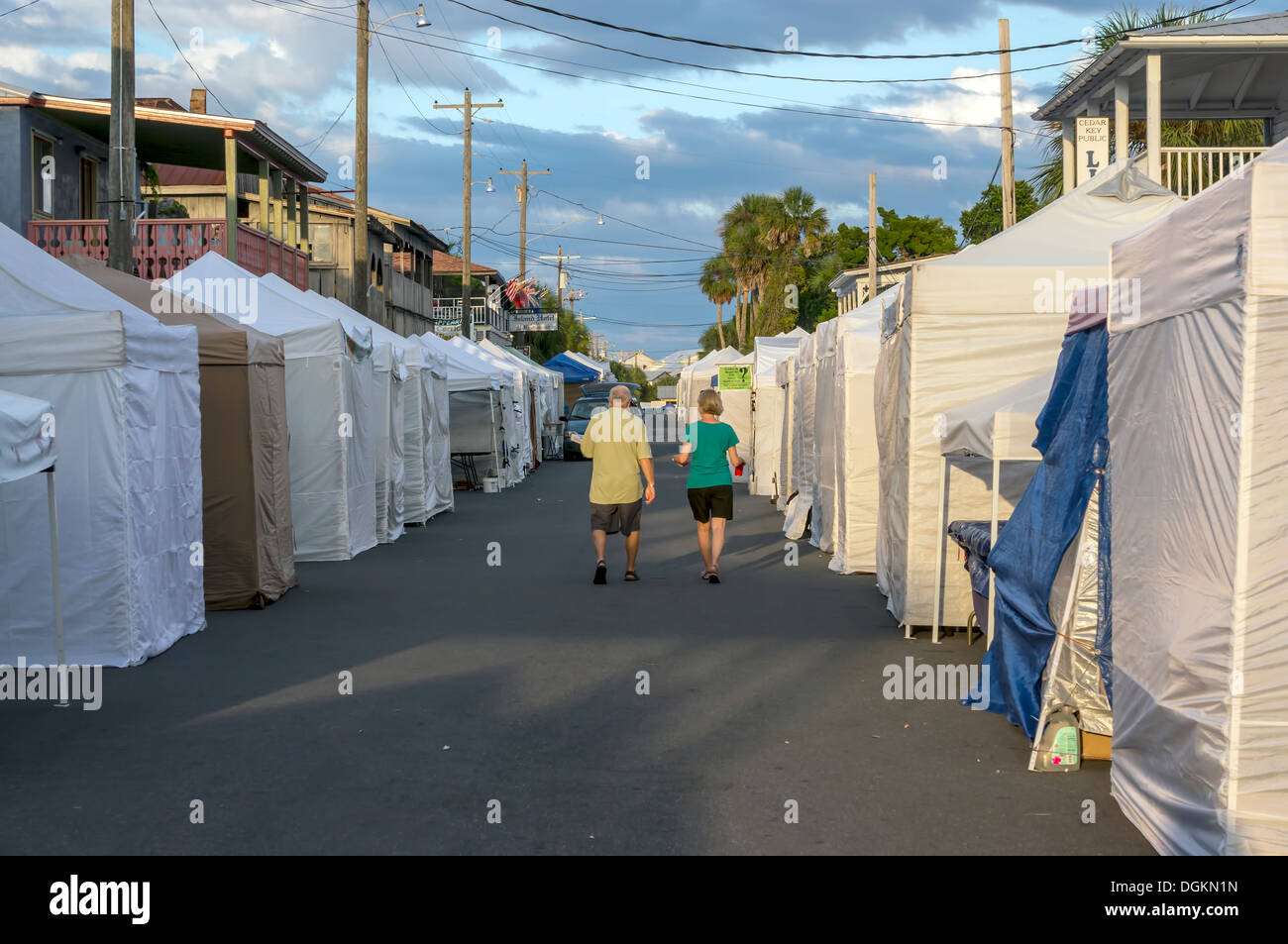 A man and woman couple walk down an empty street between closed street ...
