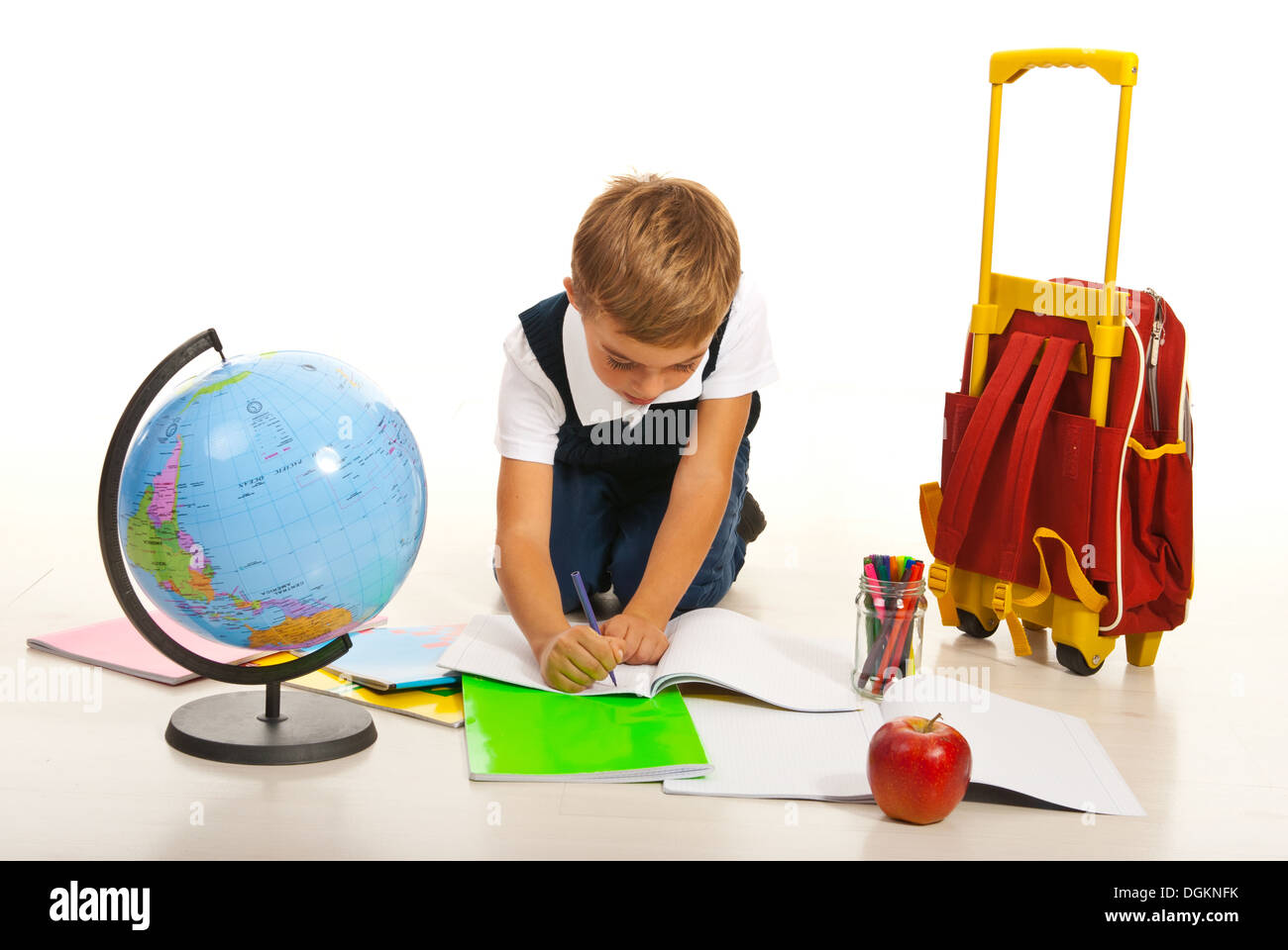 Boy making homework and sitting on floor in living room Stock Photo - Alamy