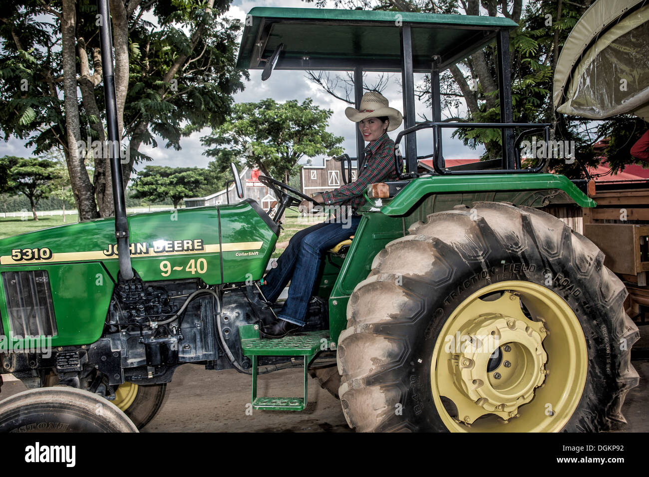 John Deere tractor. Woman driving a John Deere tractor. Female Thai ...