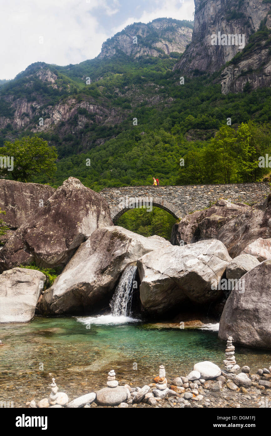Medieval bridge with hikers near Fontana, Bavona Valley, Val Bavona ...