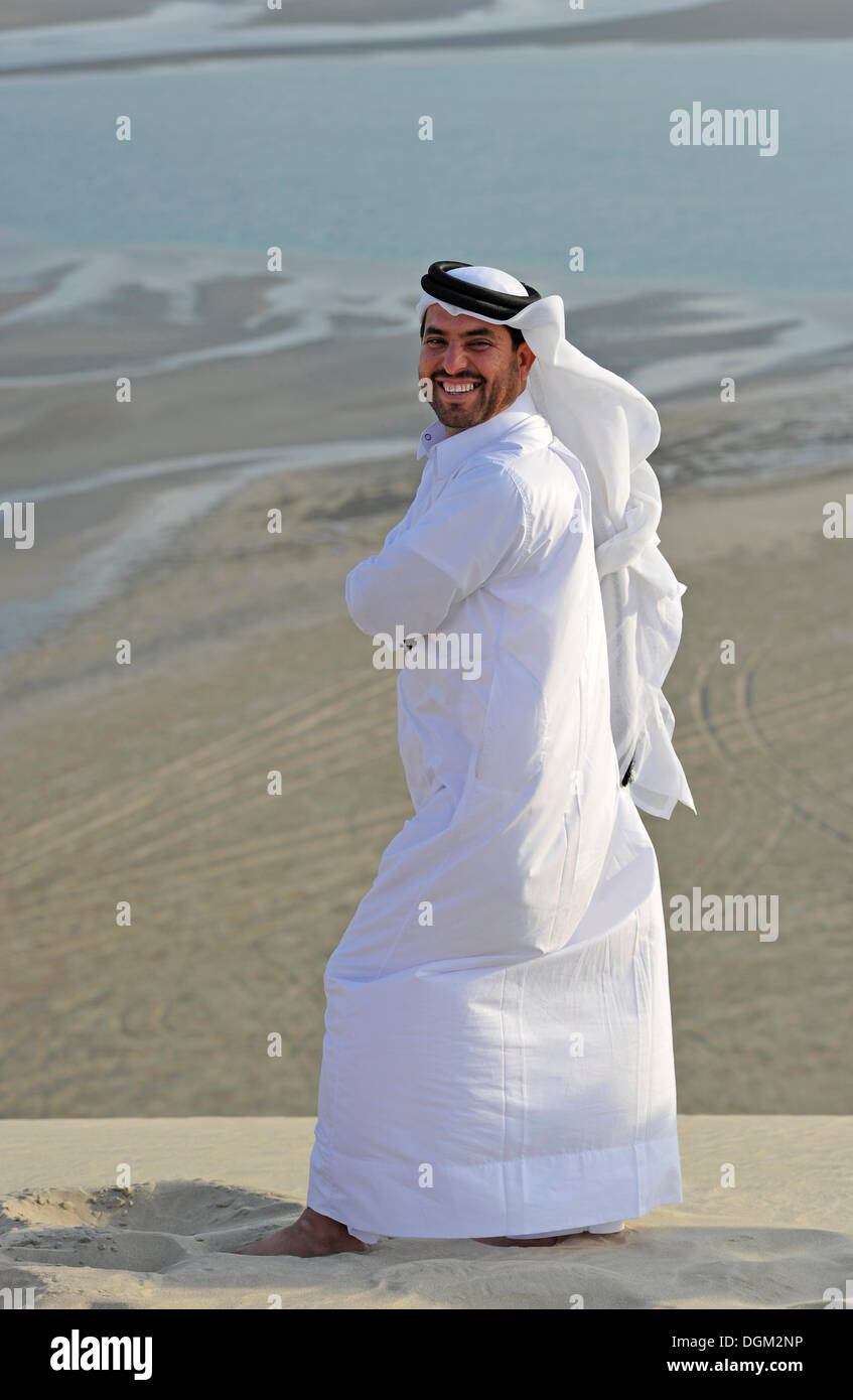 Qatari in traditional clothing with gutra, in front of Khor Al Udeid ...
