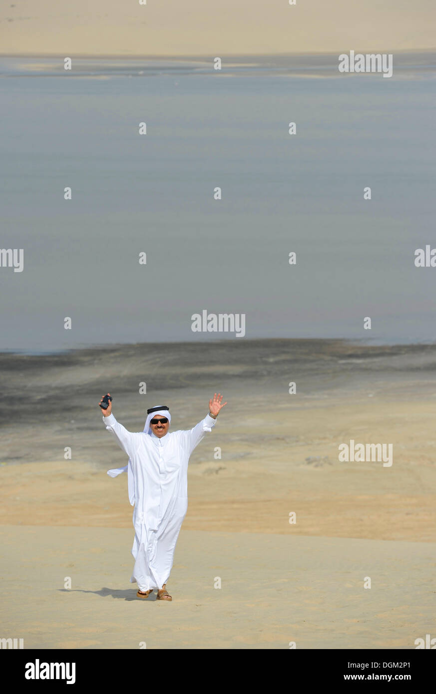 Qatari in traditional clothing with gutra, in front of Khor Al Udeid ...