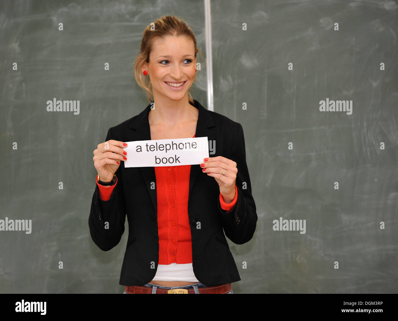 Young female teacher standing in a classroom during English lessons ...