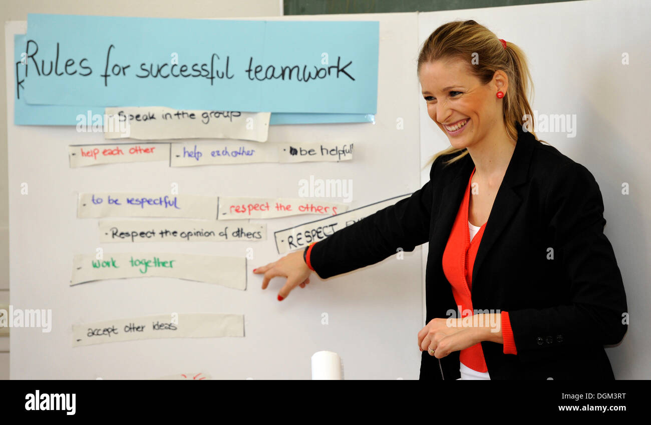 Young female teacher standing in a classroom during English lessons in ...