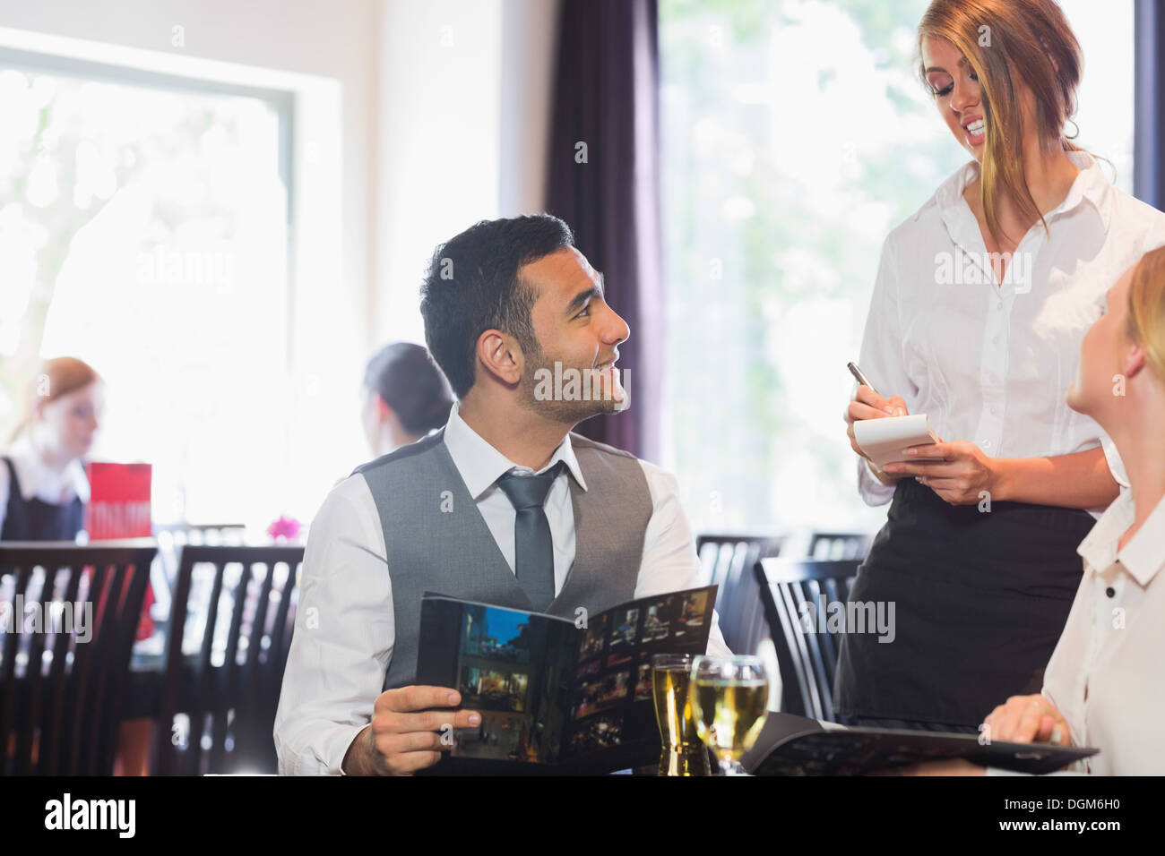 Woman taking menu from waitress hi-res stock photography and images - Alamy