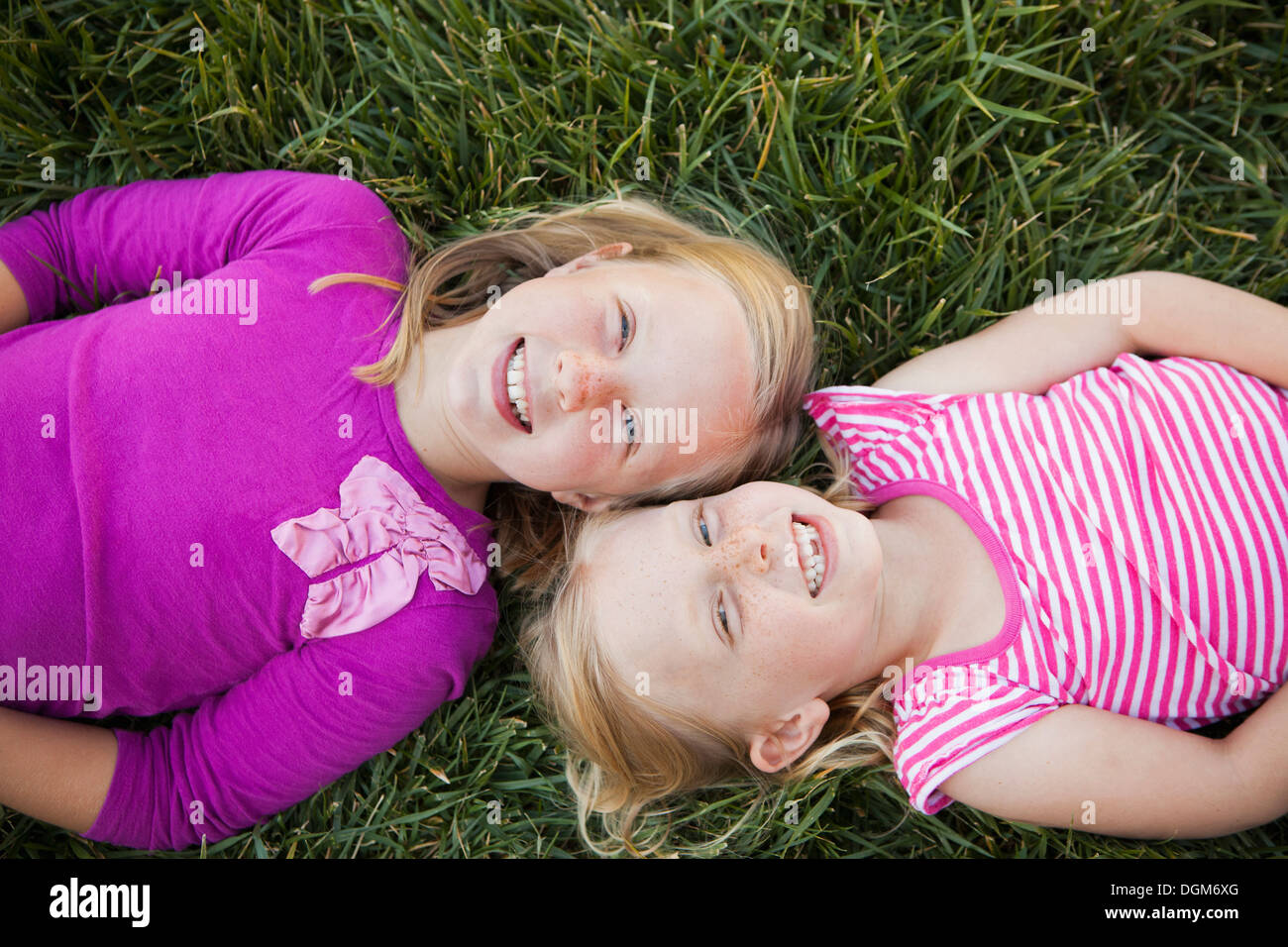 A portrait of two sisters smiling. View from above, of two girls lying ...