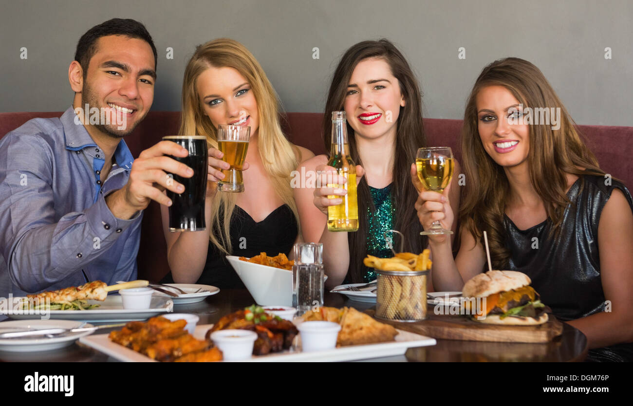 Friends having dinner together smiling at camera Stock Photo - Alamy