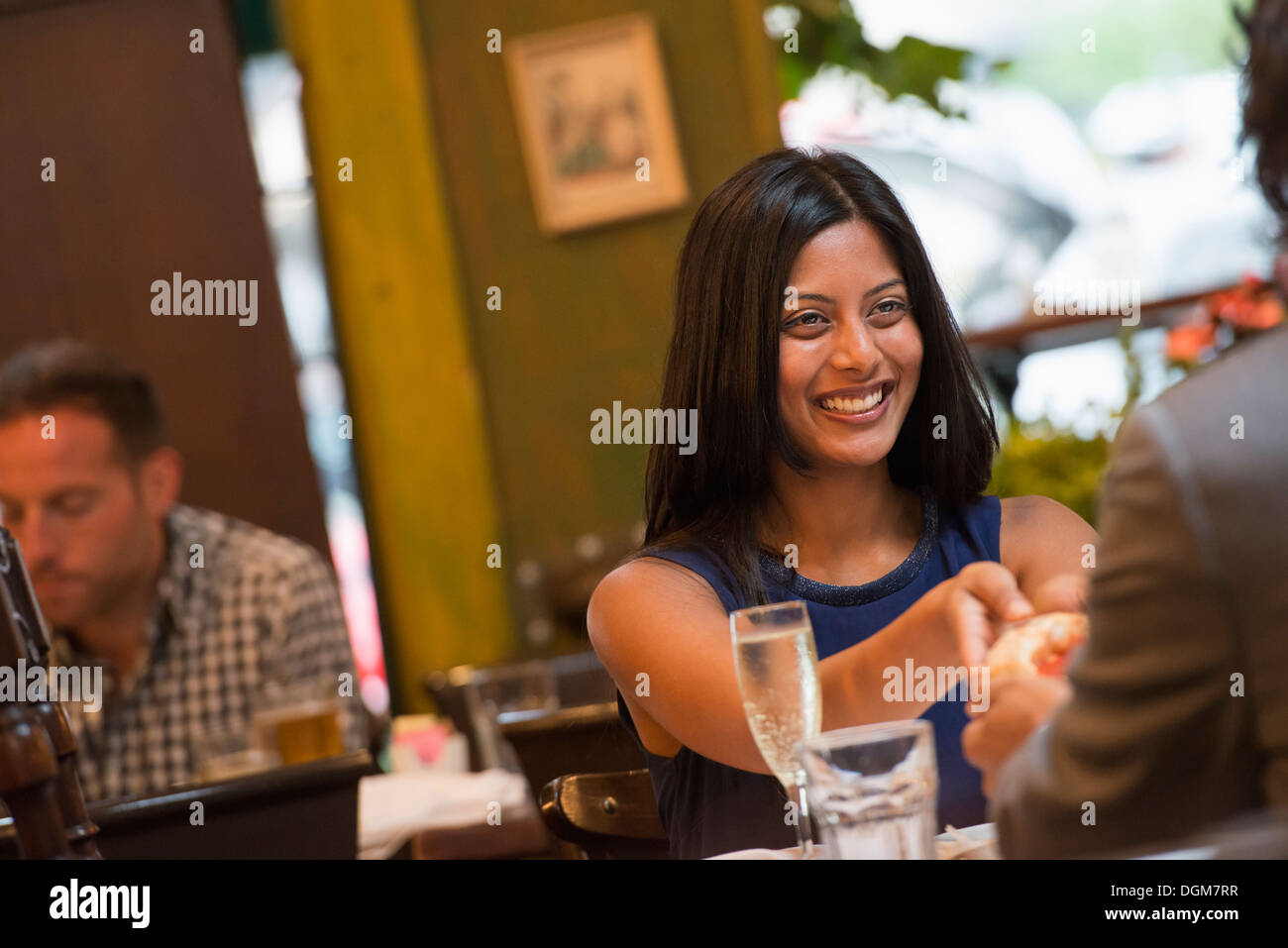 Business people. Two people seated at a table holding hands. A man in ...