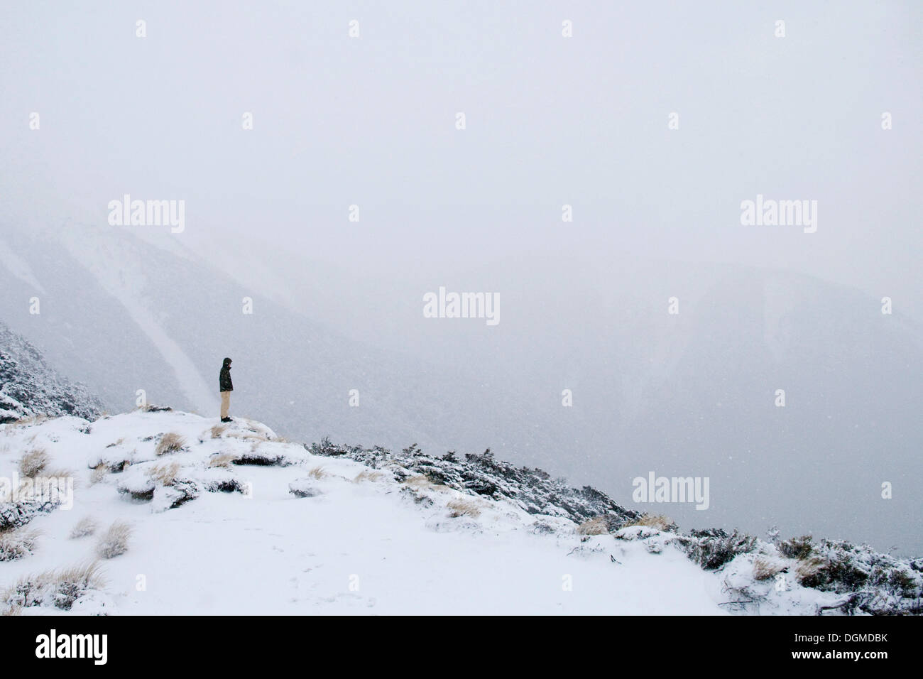 Hiker admiring the snowy valley of the Eastern Ruahine Mountains ...