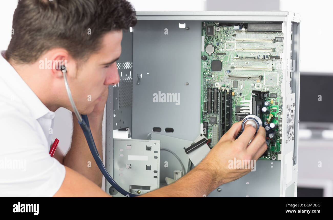 Handsome computer engineer examining hardware with stethoscope Stock ...