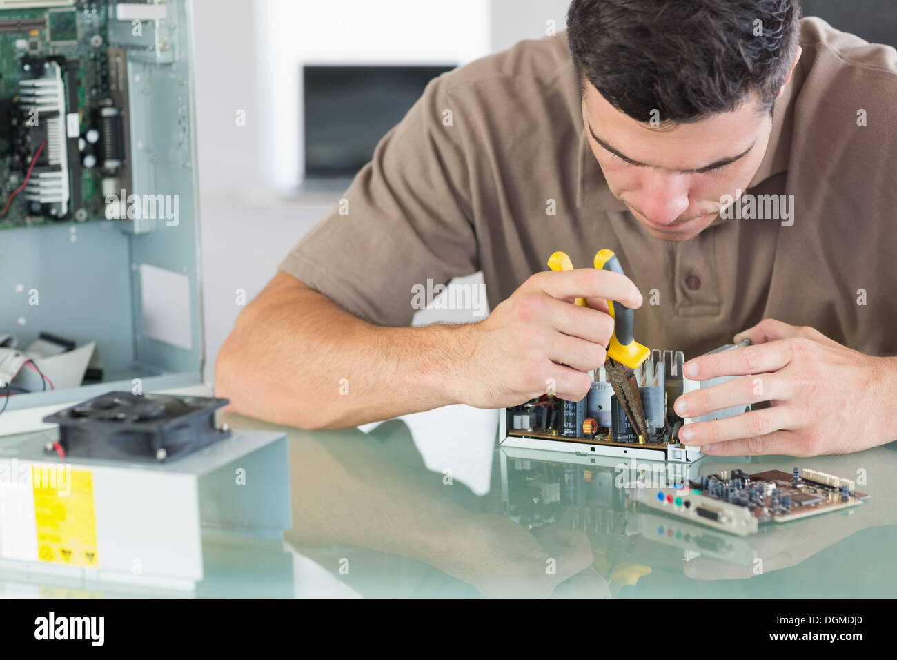 Handsome frowning computer engineer repairing hardware with pliers ...