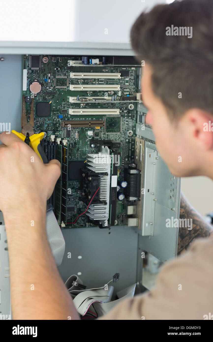 Computer engineer repairing open computer with pliers Stock Photo - Alamy