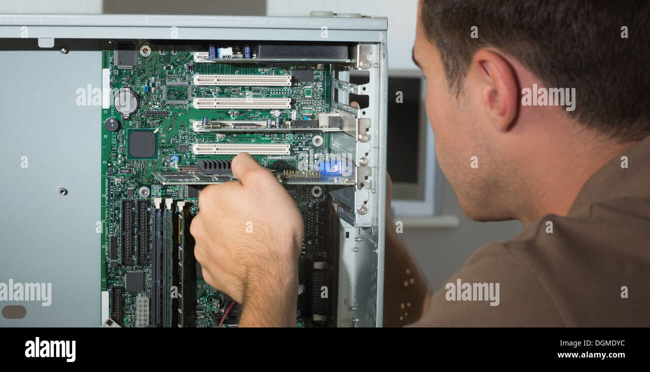 Computer engineer examining open computer Stock Photo - Alamy