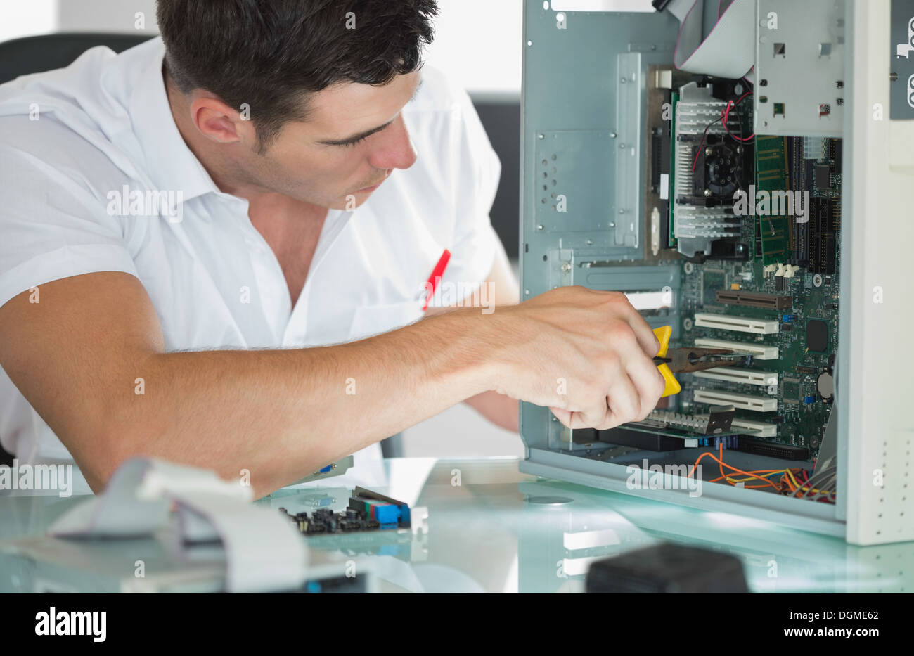 Handsome computer engineer repairing computer with pliers Stock Photo ...