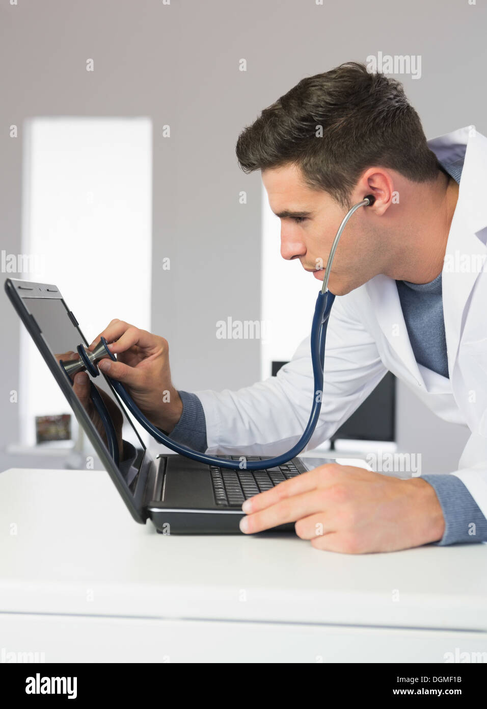 Attractive computer engineer examining laptop with stethoscope Stock ...