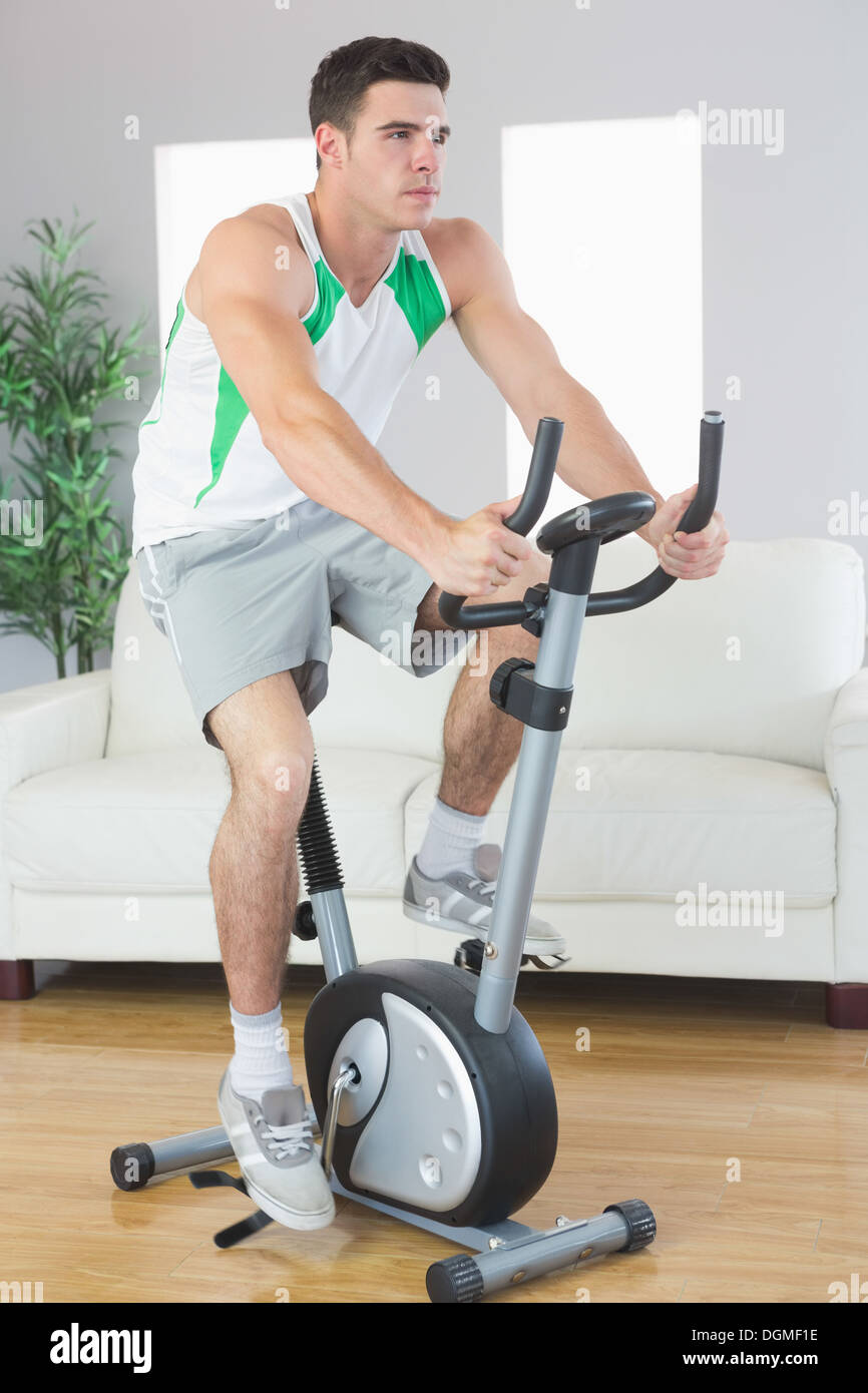 Determined handsome man training on exercise bike Stock Photo - Alamy