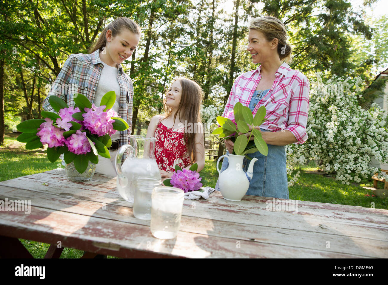 Three people gathering flowers and arranging them together. A mature ...