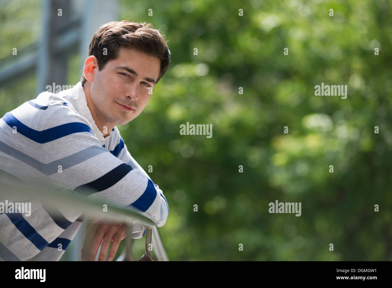 Summer. Business people. A man leaning on a railing relaxing. Off grid ...