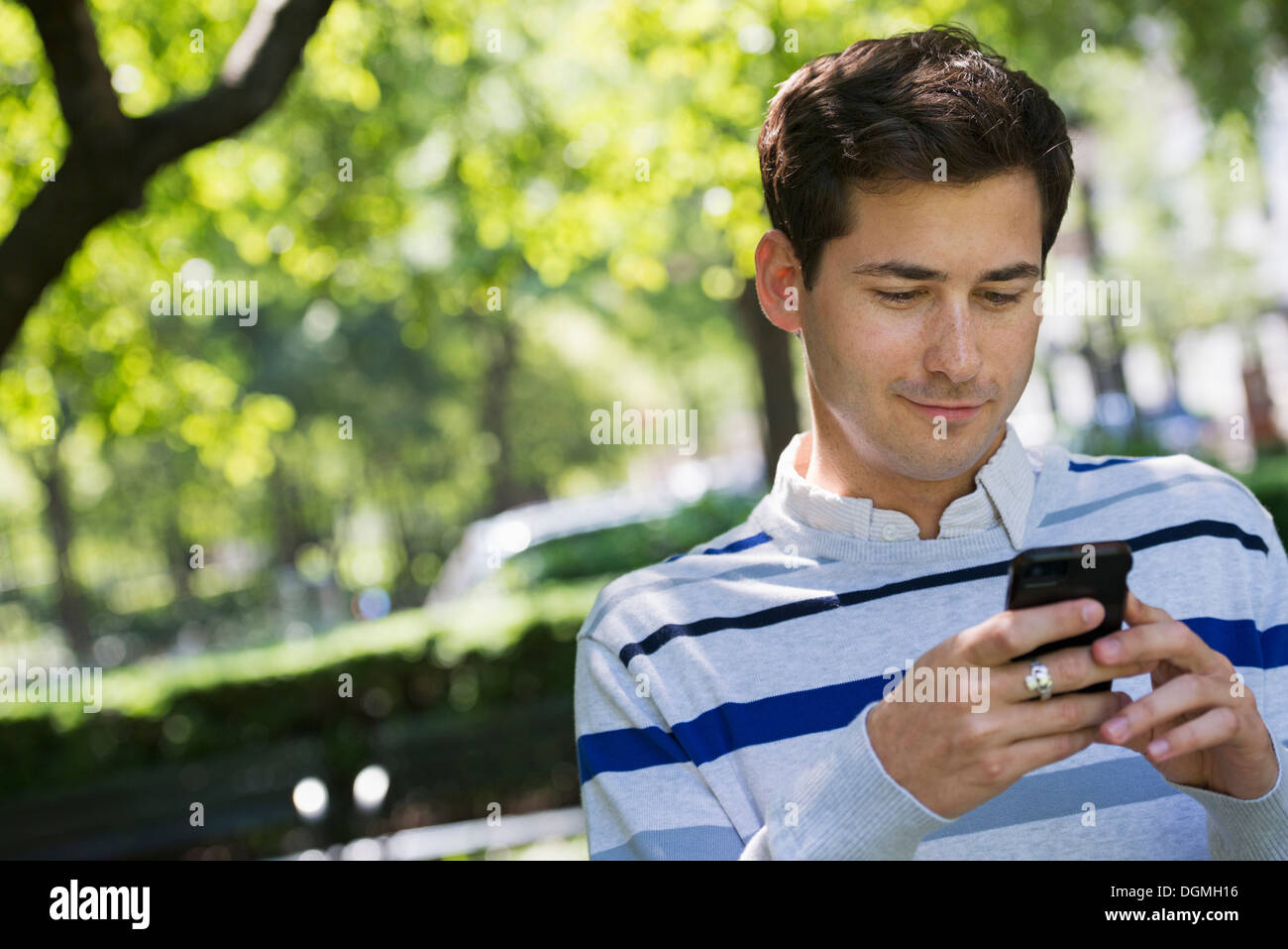 Summer. Business people. A man checking his smart phone for messages ...