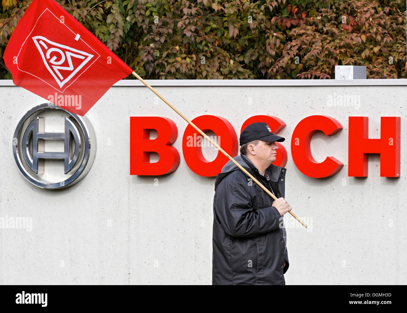 Worker carrying an IG Metall flag in front of the Bosch factory in Buhl ...