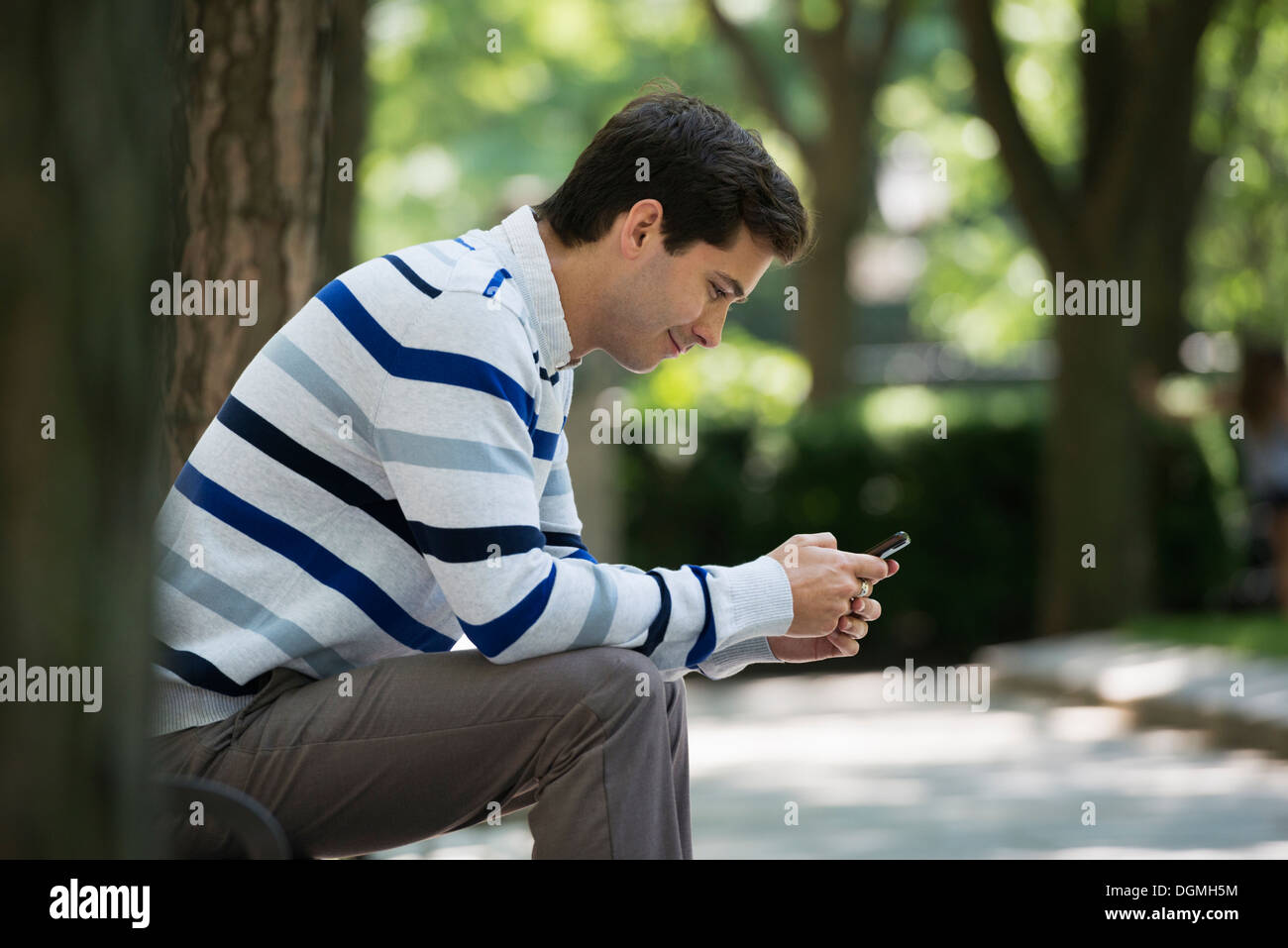 Summer. Business people. A man checking his smart phone for messages ...