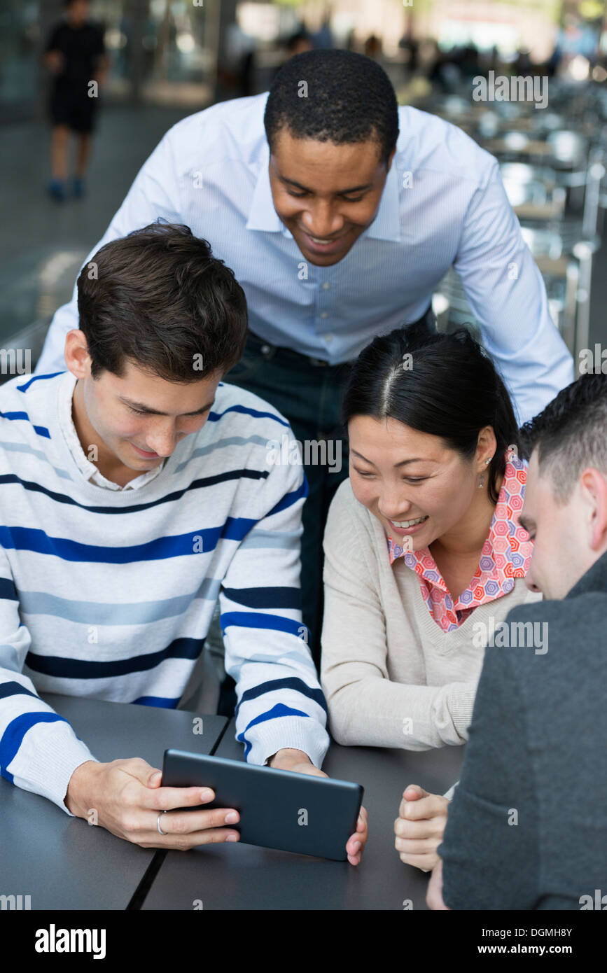 Business people on the move. Four people gathered around a digital ...
