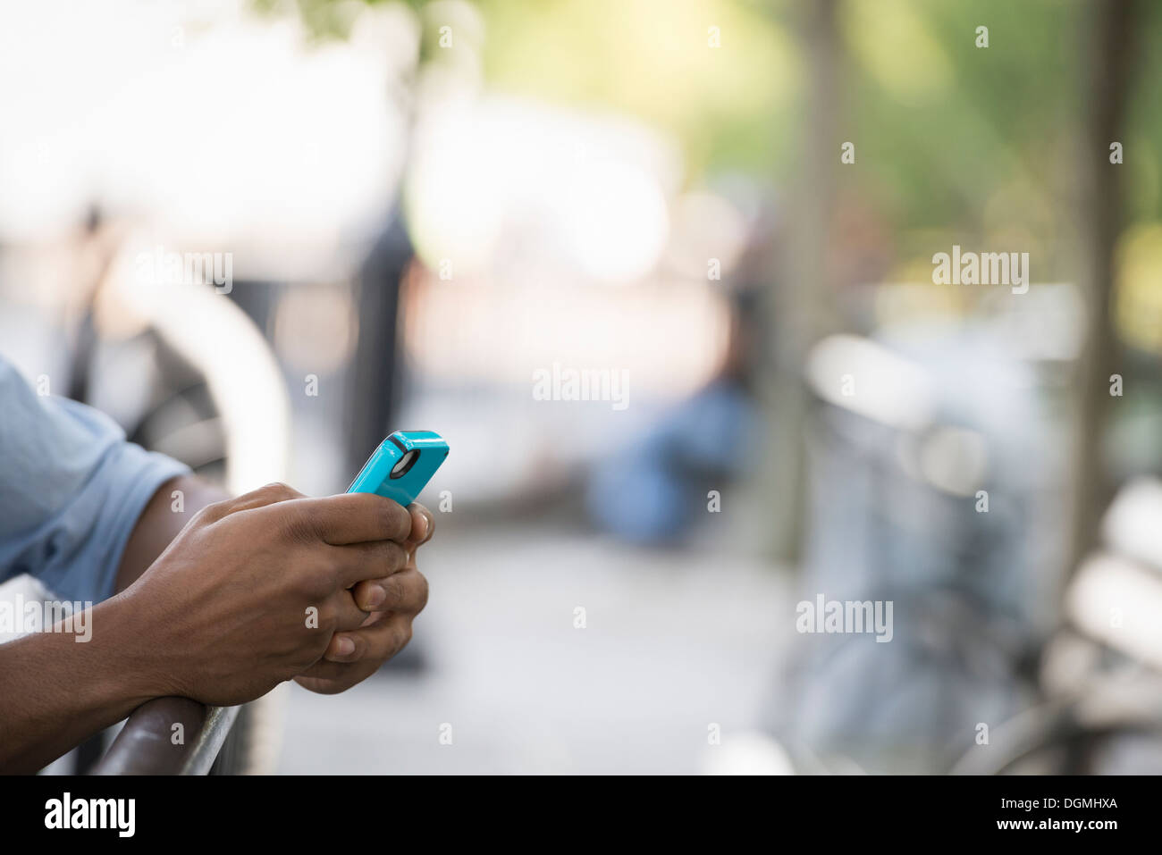 Summer In The City A Man Sitting On A Bench Using A Smart Phone Stock