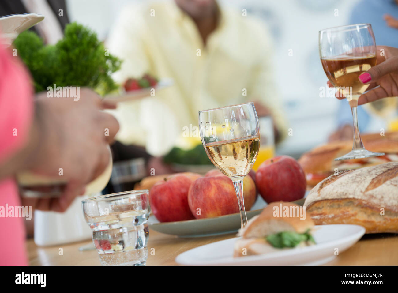 An informal office event. People handing plates of food across a buffet ...