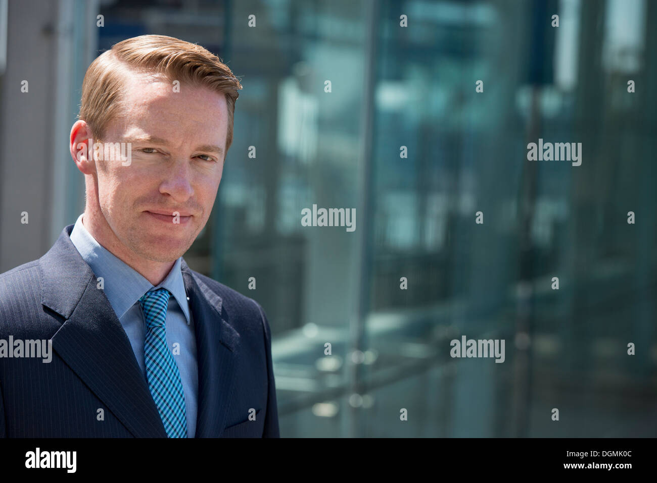 A man in a business suit outside a building with a glass exterior Stock ...