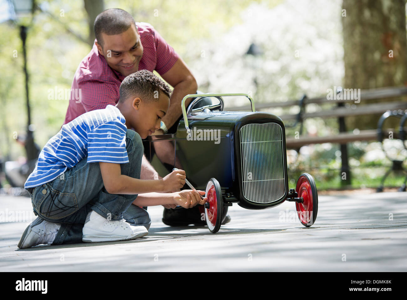 A boy repairing an old fashioned toy peddle car Stock Photo - Alamy