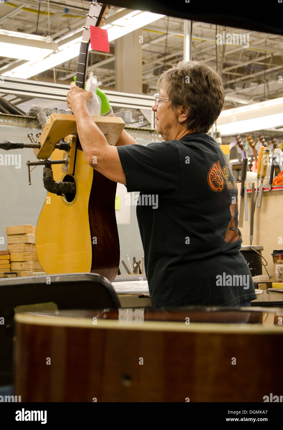 Woman working on guitar neck during production process at Martin ...