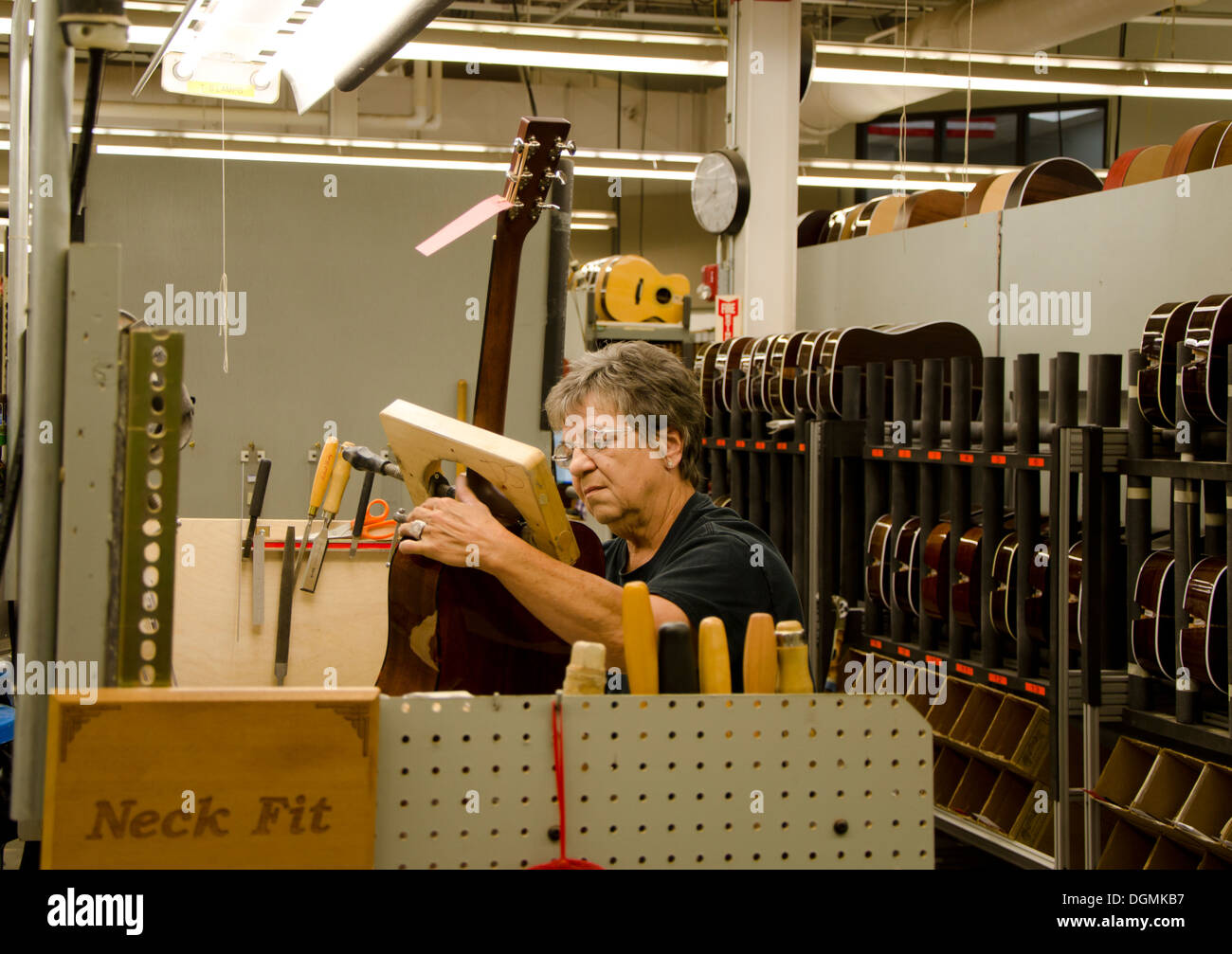 Woman working on guitar neck during production process at Martin ...