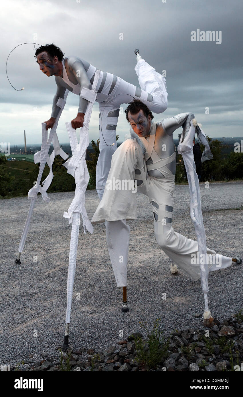 Two performers on stilts, dressed fantastically, summer night show at ...