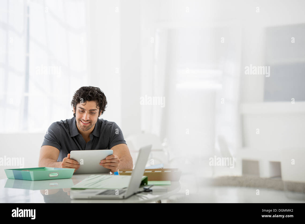 Business. A light airy office environment. A man sitting holding a ...