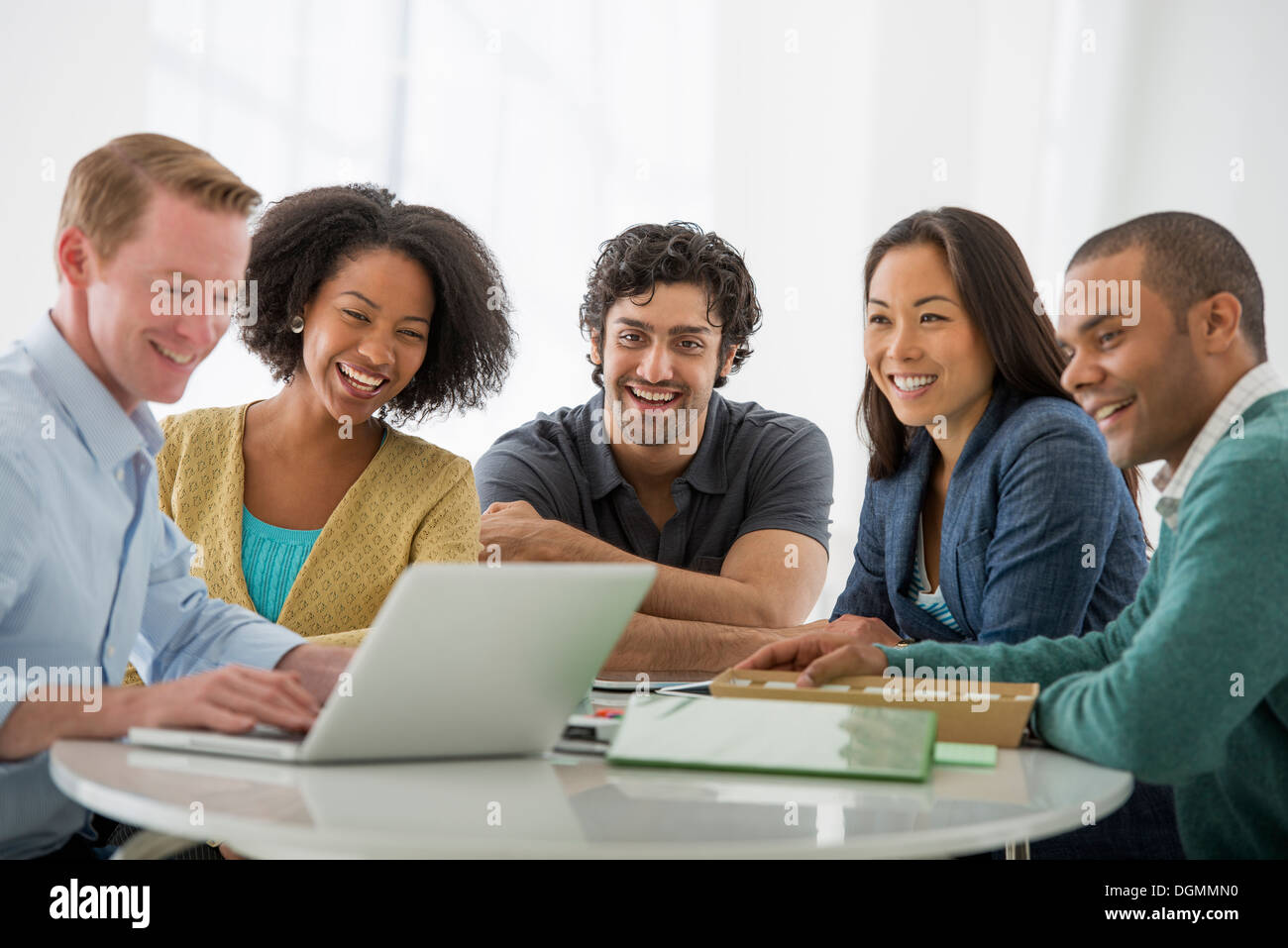 Business meeting. A group sitting down around a table Stock Photo - Alamy