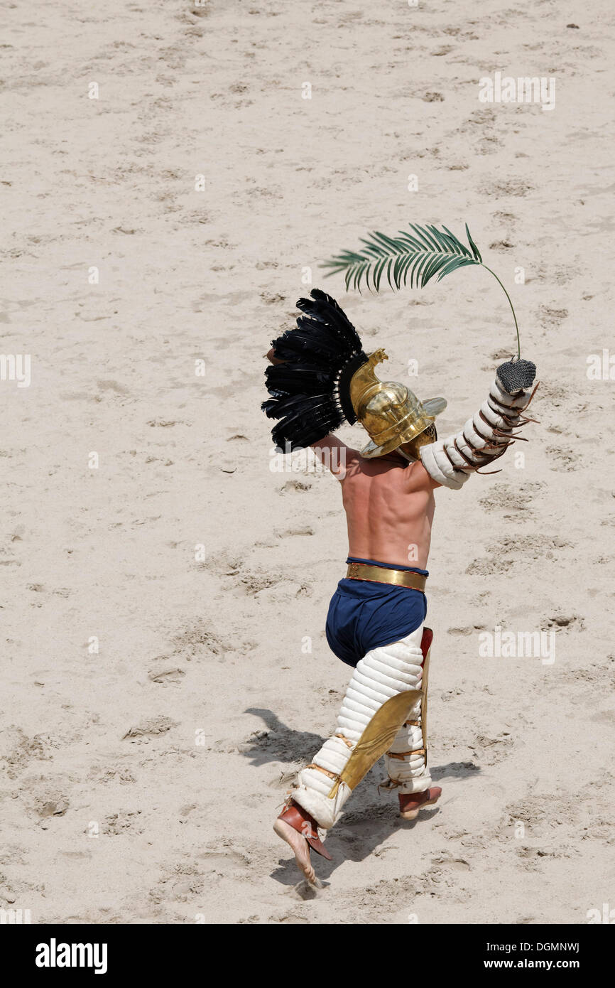 Victorious Thraex running a lap of honor waving a palm frond, a ...