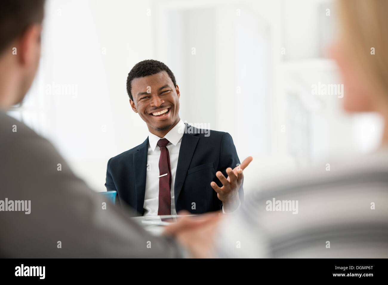 Office interior. Three people sitting around a table at a business ...