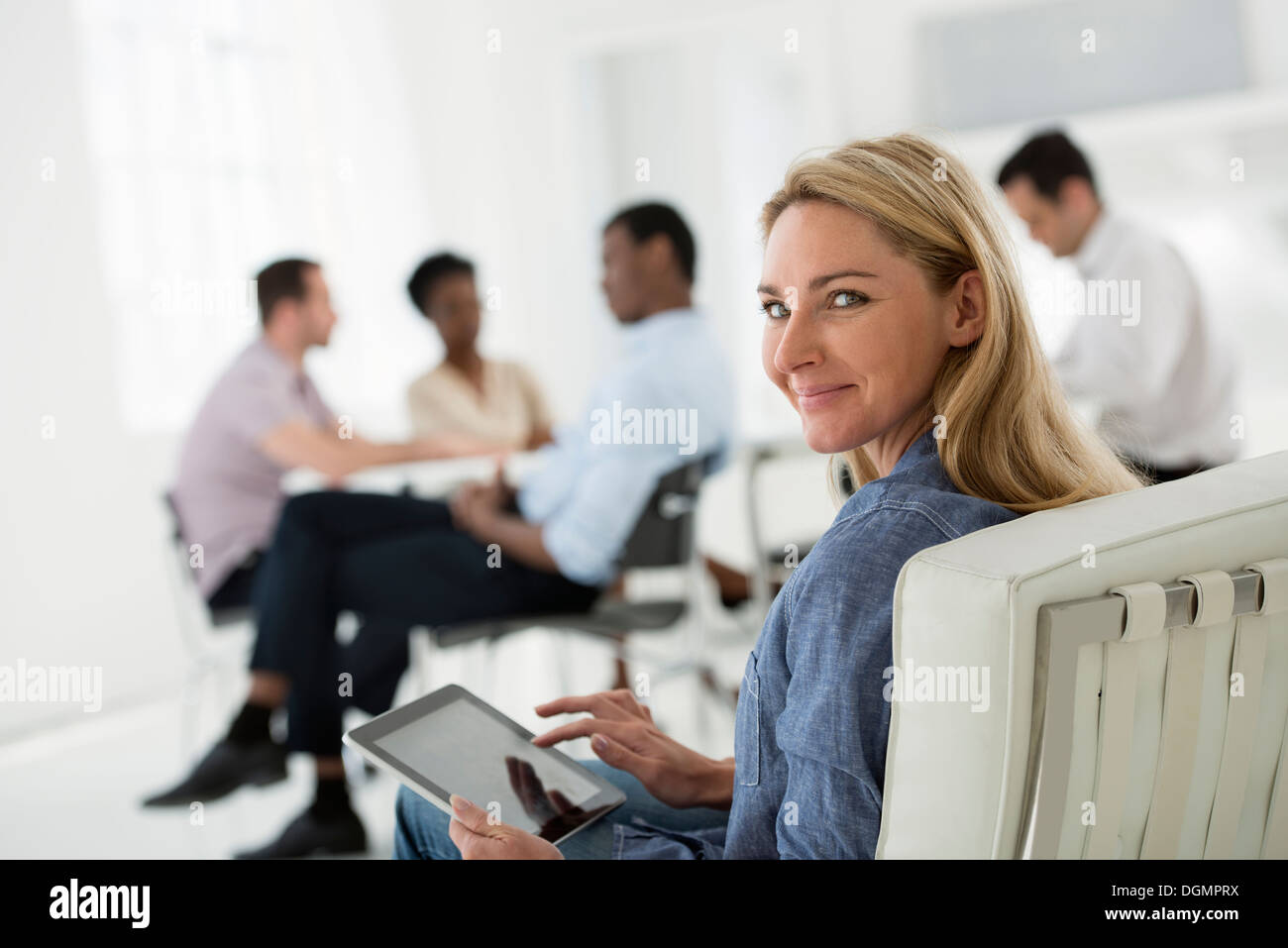 Office interior. Meeting. One person looking over her shoulder and away ...