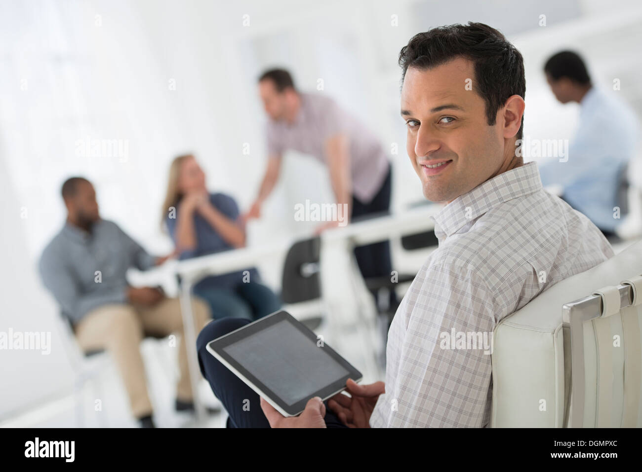 Office interior. Meeting. One person looking over her shoulder and away ...