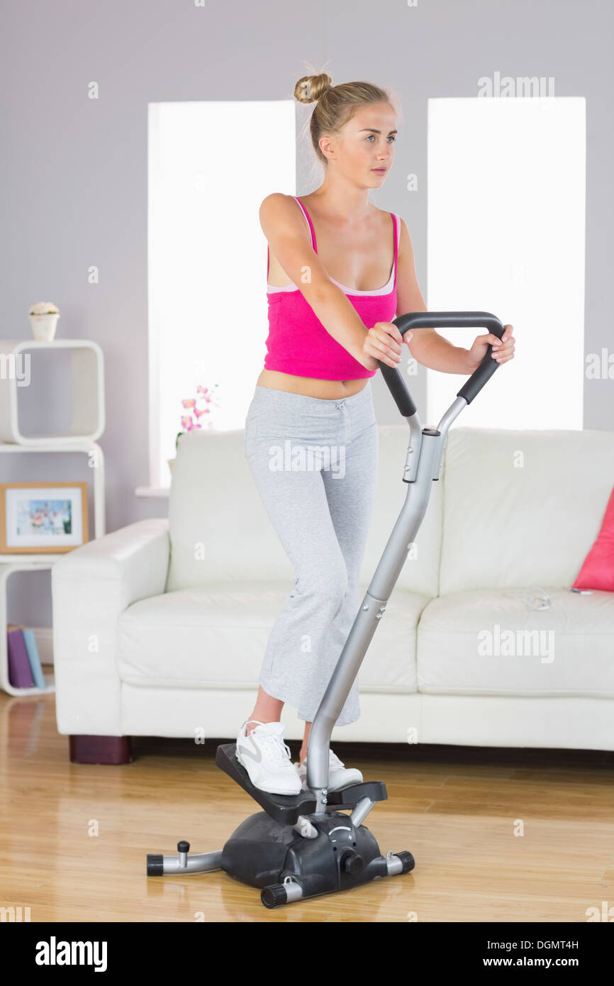 Sporty determined blonde training on step machine Stock Photo - Alamy