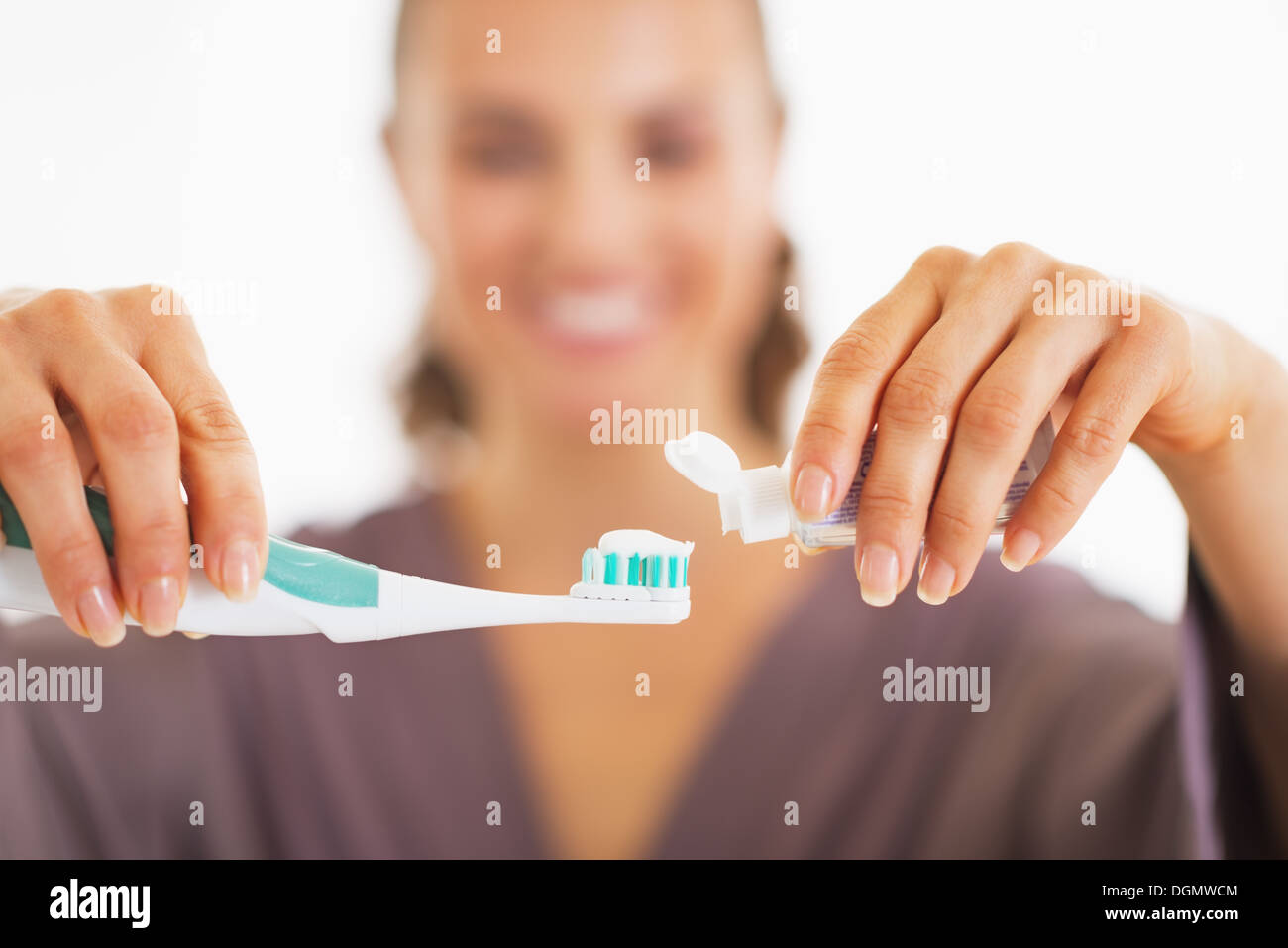 Closeup on happy young woman squeezing toothpaste from tube Stock Photo ...