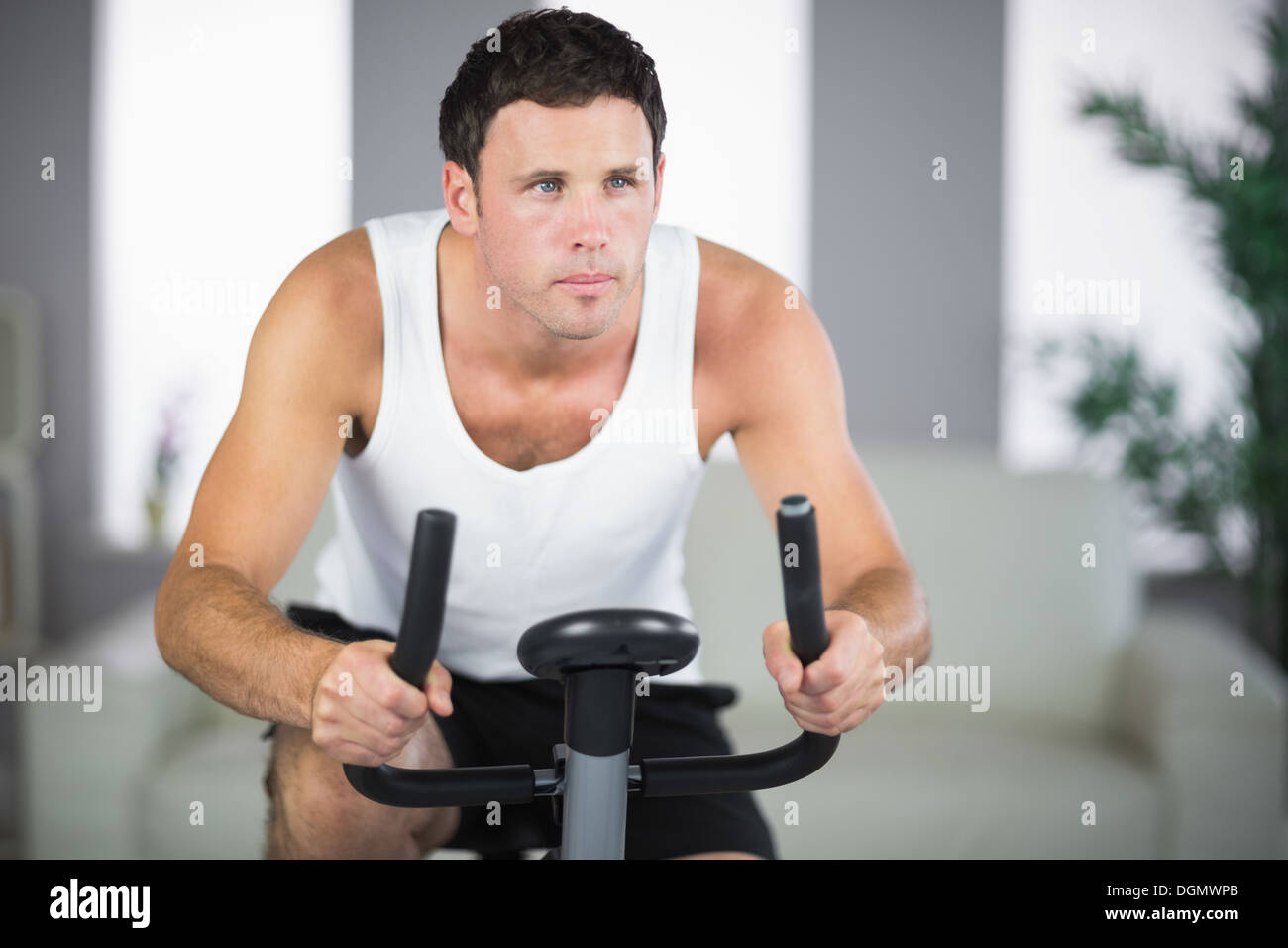 Attractive fit man exercising on bike Stock Photo - Alamy