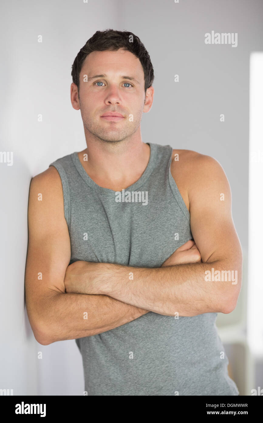Sporty attractive man leaning against wall with arms crossed Stock ...