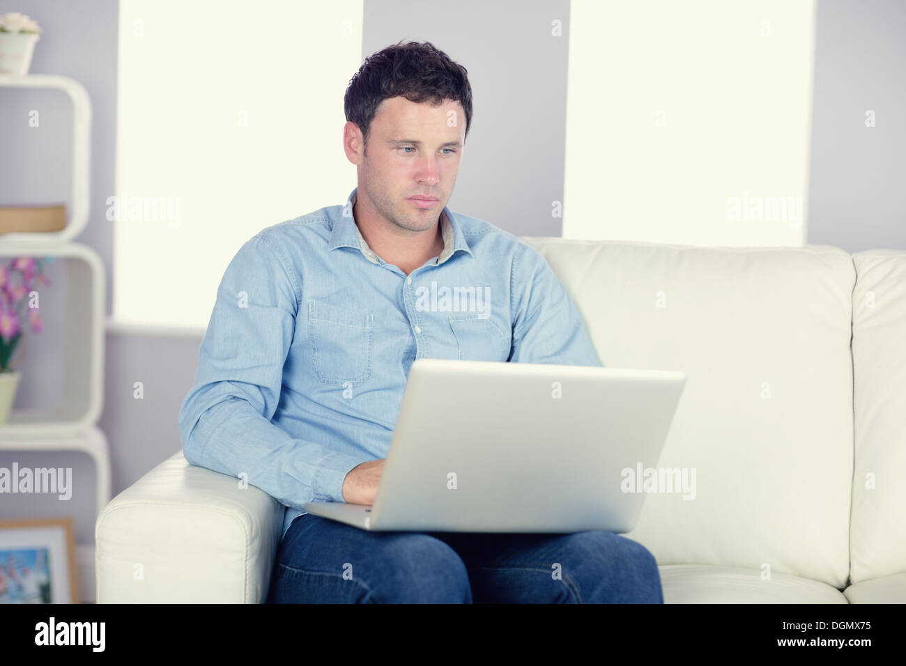 Man on couch with laptop hi-res stock photography and images - Alamy