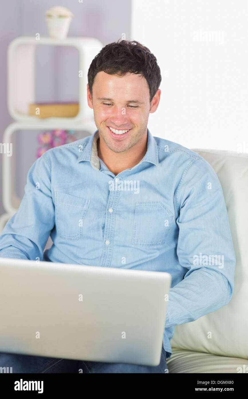 Man on couch with laptop hi-res stock photography and images - Alamy