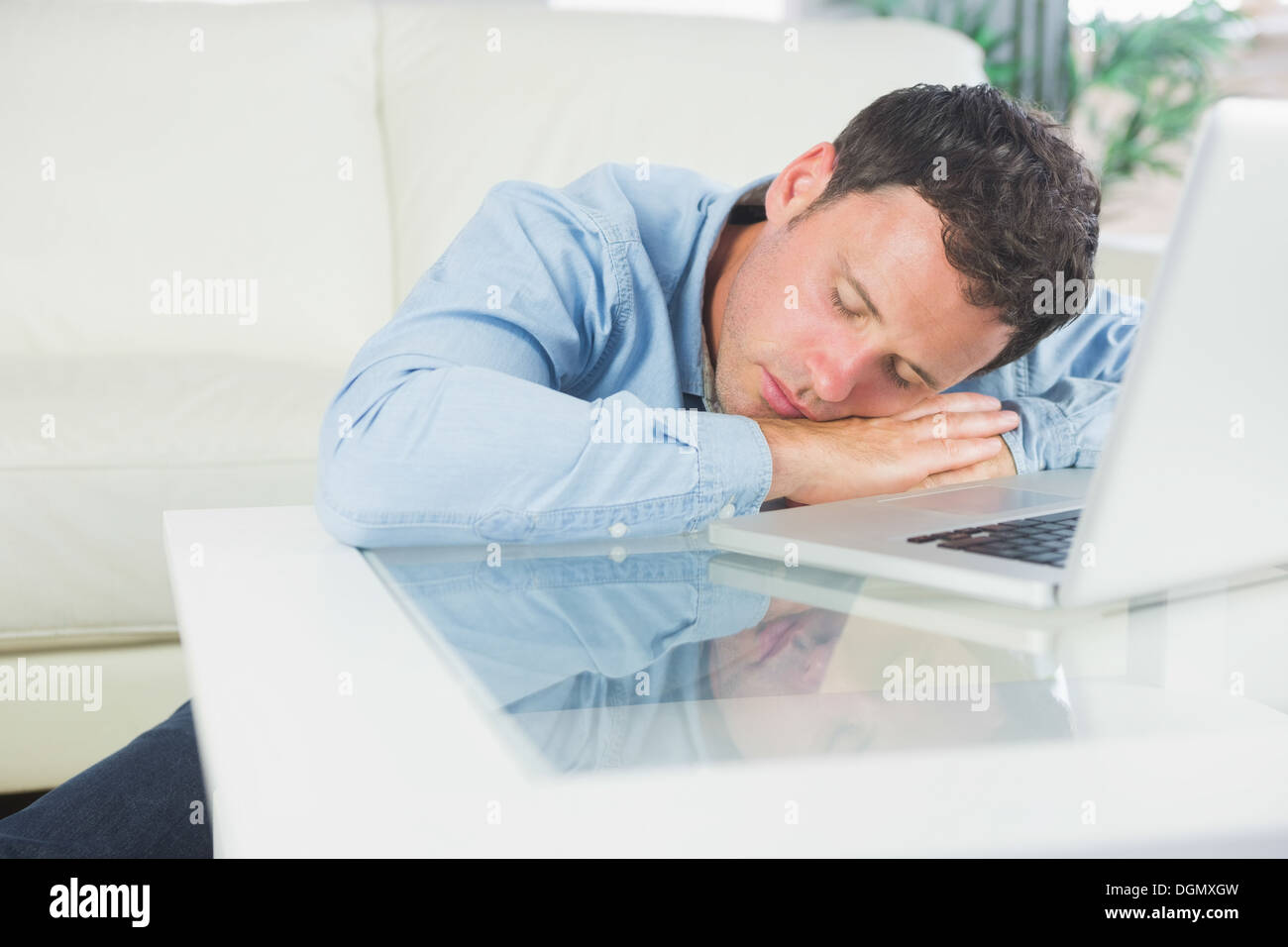 Tired casual man sleeping with head resting on table Stock Photo - Alamy
